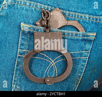Black steel handcuffs in back jeans pocket Stock Photo - Alamy