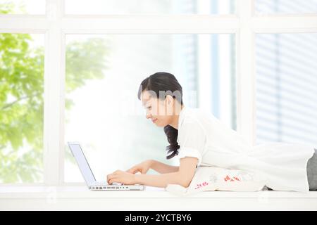 Woman lying down and opening computer Stock Photo - Alamy