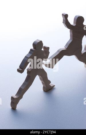Wood carving of two running businessmen Stock Photo - Alamy