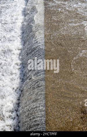 cascade concrete water spillway channel on mountain river with mountain ...