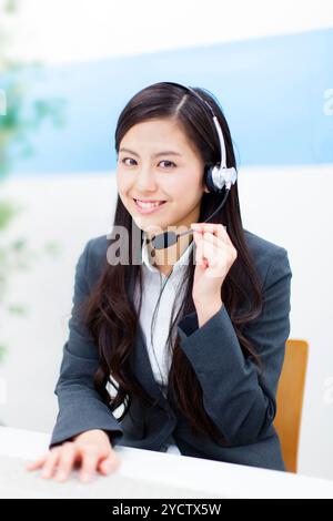 Portrait of call center operator at work. Group of people in a headset ready to help customers ...