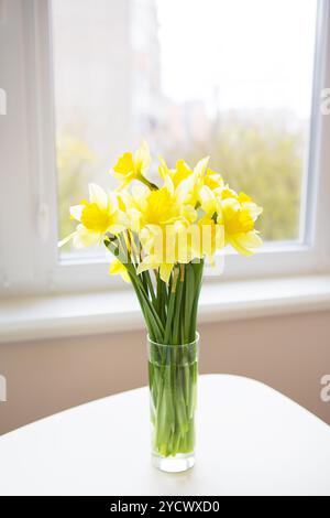 Posy of bright yellow daffodils on white wooden table Stock Photo - Alamy