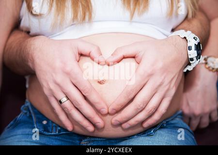 Pregnant Belly with fingers Heart symbol. Beautiful Young Pregnant ...