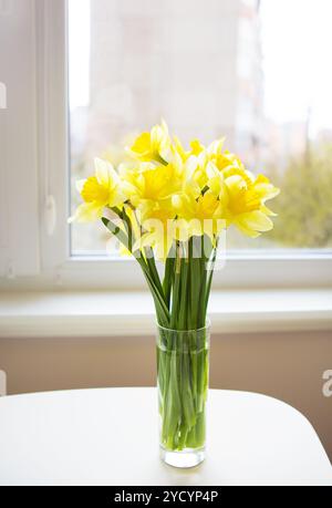 Posy of bright yellow daffodils on white wooden table Stock Photo - Alamy