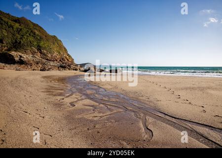 A steam drains across the wet beach at Pentewan Sands, St Austell ...