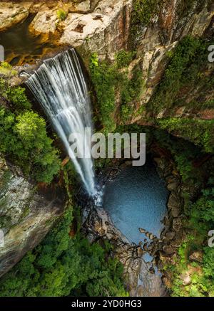 A majestic waterfall cascading down a sheer rock face into a tranquil ...