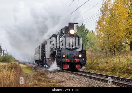 Old Russian locomotive on the railway. Old black locomotive. Smoke from ...
