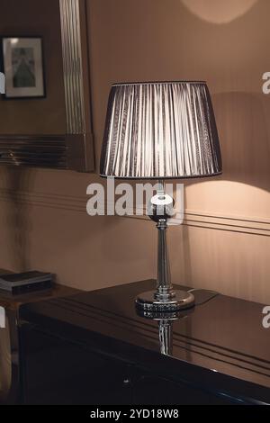 Chest of drawers, floor lamp and table in interior of living room Stock ...