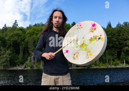 Shamanic male playing sacred drum with stick Stock Photo - Alamy