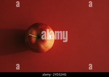 Red apple forming a shadow against black backround Stock Photo - Alamy