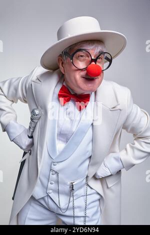 Ð¡lown in a white coat, hat and large red patent leather clown boots ...