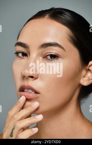 A woman with striking features gazes thoughtfully into the distance ...