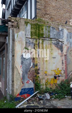 Crumbling remains of one damp, moss-covered walls of an old demolished ...