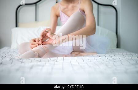 A girl ballet student, Wear ballet shoes in bed and prepare to practice ...