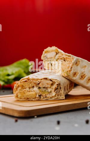 Freshly grilled chicken wrap cut in half, revealing creamy filling ...