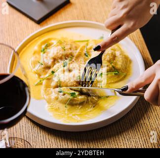 Woman eating ravioli with parmesan cheese Stock Photo - Alamy