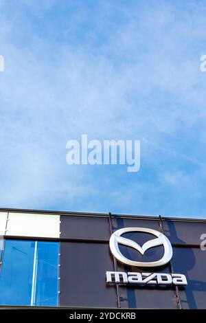 Mazda brand logo on bright blue sky background Stock Photo - Alamy