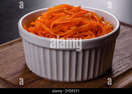 Bowl of korean carrot salad and spices on color background Stock Photo ...
