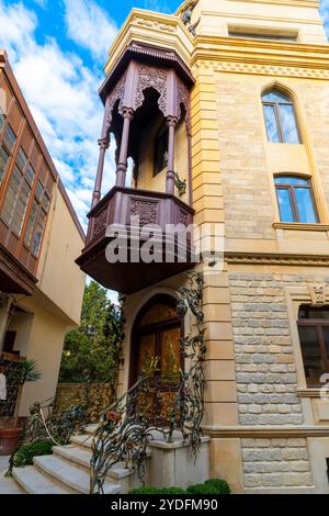 A traditional Azerbaijani building with ornate wooden balcony by Qüllə ...
