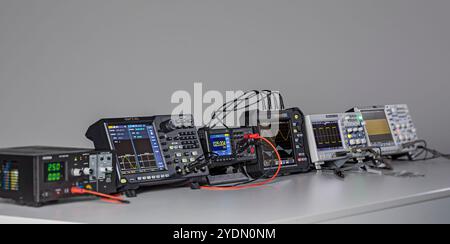 Various measuring devices and oscilloscopes set up on a work table in a ...