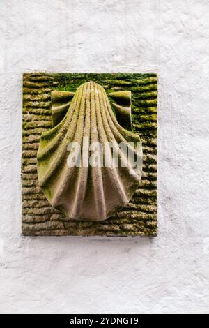 A shell symbol, representing pilgrimage, is affixed to a rustic brick ...
