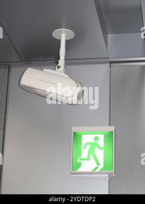 Emergency exit sign and security camera Stock Photo - Alamy