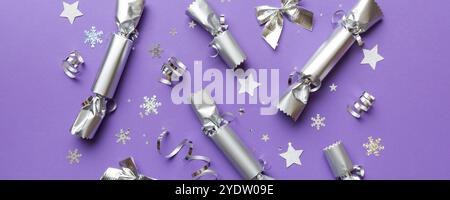 Christmas crackers with shiny confetti on color background, top view ...