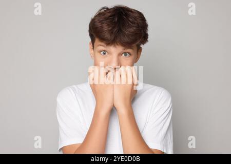 Portrait of scared teenage boy on black background Stock Photo - Alamy