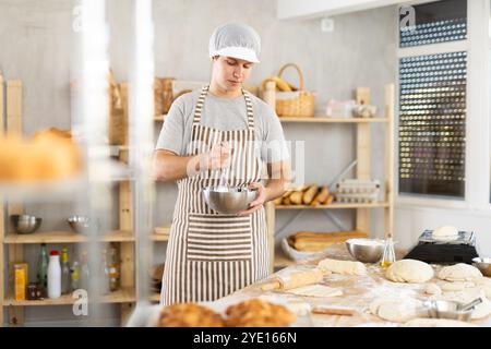 Experienced baker spreading flour in home kitchen for food preparation ...