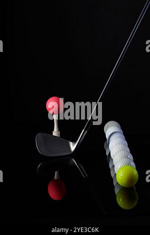 golf club and golf ball photographed against a dark background with ...