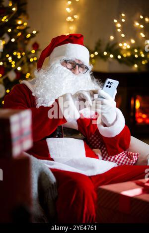 santa claus with smartphone and christmas tree Stock Photo - Alamy