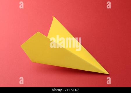 Yellow paper plane on red background Stock Photo - Alamy