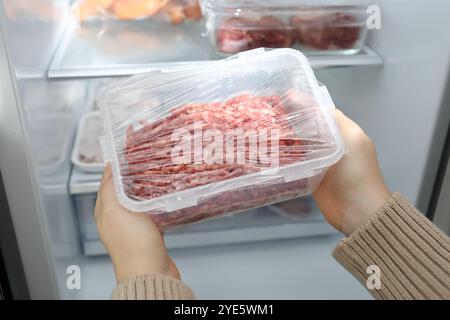 Woman taking frozen minced meat out of fridge, closeup Stock Photo - Alamy