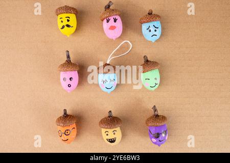 Painted acorns with expressive faces on peach background. Showcasing ...