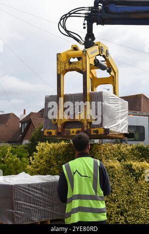 Order load of brick blocks deliver by lorry uploading Stock Photo - Alamy