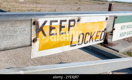 Metal Gate on the beach at Dungeness with a large yellow keep locked ...