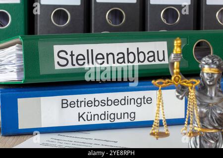 Kündigung vor Ordnern mit der Aufschrift STELLENABBAU und ...