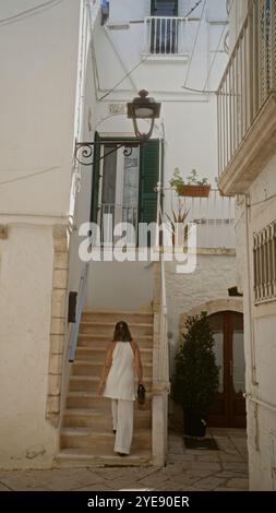 Woman walking up rustic steps on a leaf-covered woodland path near the ...