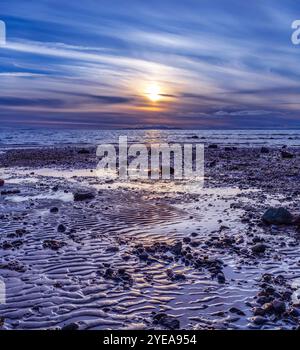 sunset over the picturesque white sand beach and turquoise waters at La ...
