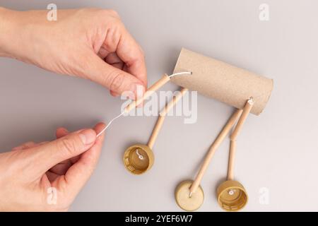 Assembling DIY reindeer puppet leg with cardboard tube string bottle ...