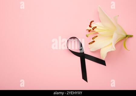 White liles flowers with black ribbon. Mourning or funeral background ...