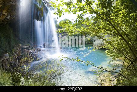 Empty natural river pool surrounded by rocks trees and green hills in ...