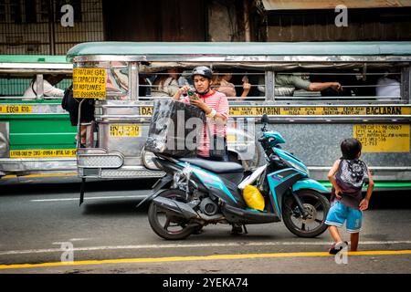 A filipino man packs his bike case as jeepneys speed past. In the ...