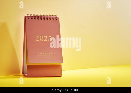 pink color 2025 desk calendar against blue color background Stock Photo ...