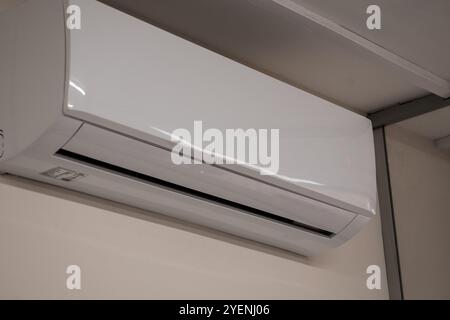 Modern wall-mounted air conditioner installed in a room, providing ...
