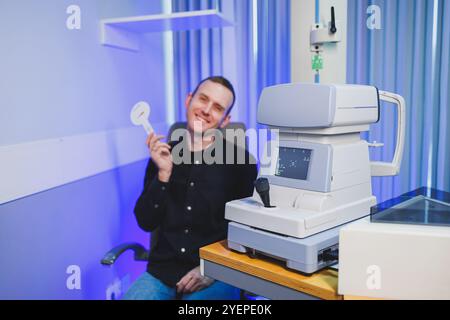 A male ophthalmologist checks the eyesight of a young girl using a ...