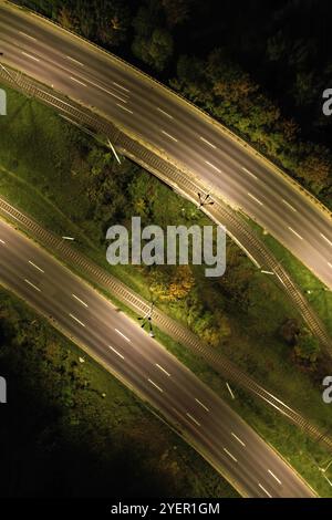Night cityscape view from tram descending through forest and ...