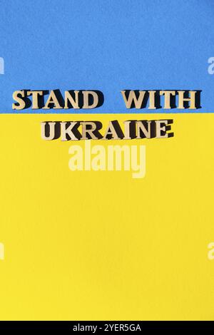 Ukrainian national flag made of paper. STAND WITH UKRAINE text. Stop ...