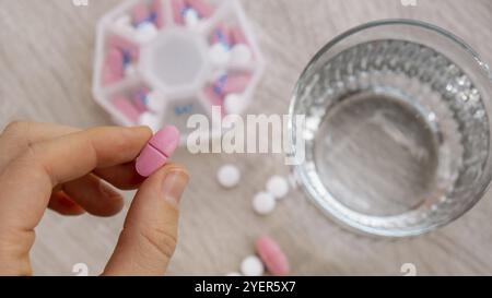 Woman sorting pills Organizer weekly shots Closeup of medical pill box ...