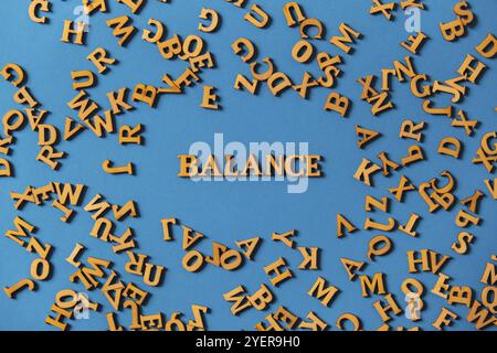 Word BALANCE made out of wooden letters on bright blue background ...